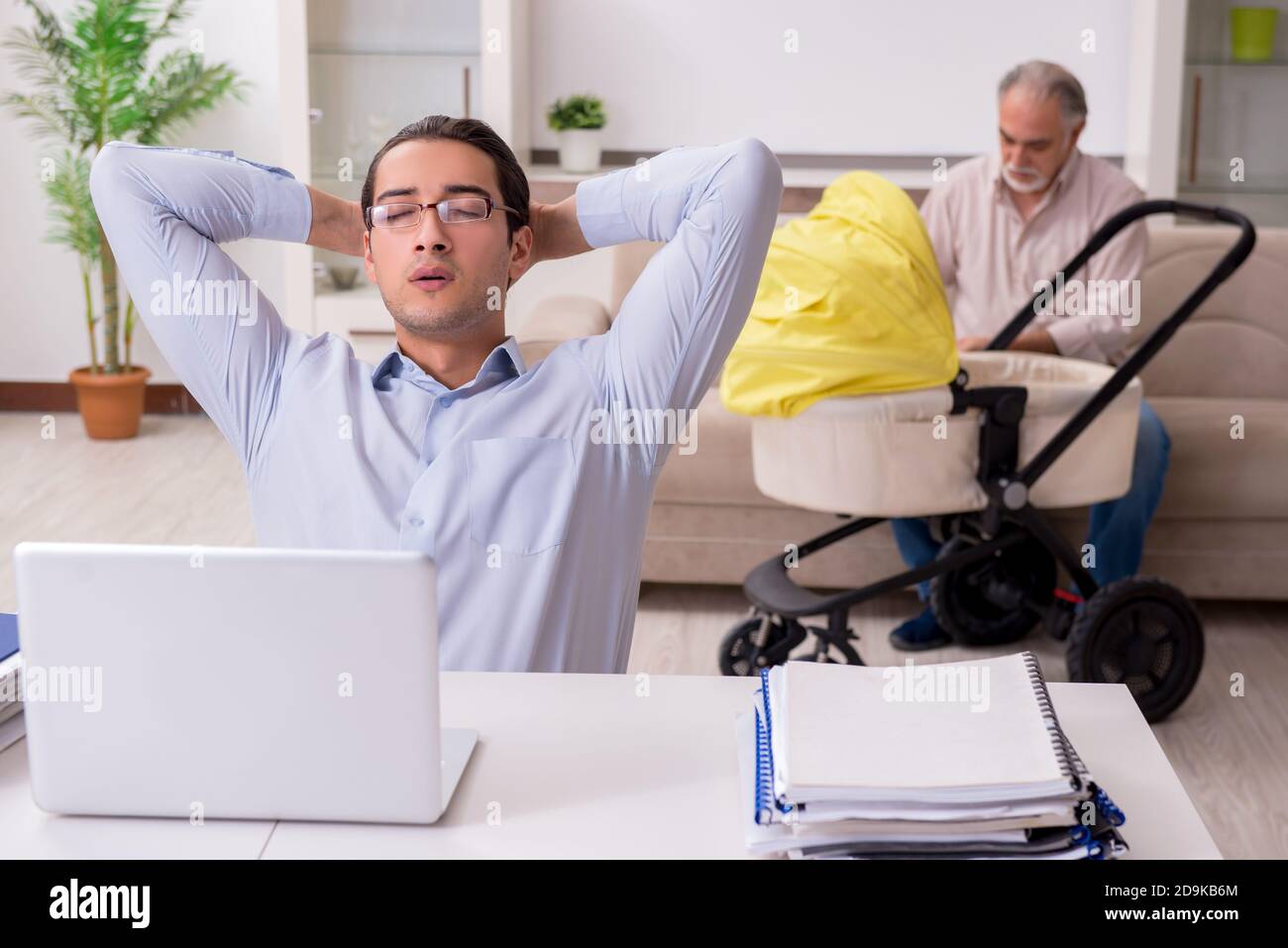 Old grandfather looking after newborn at home Stock Photo - Alamy