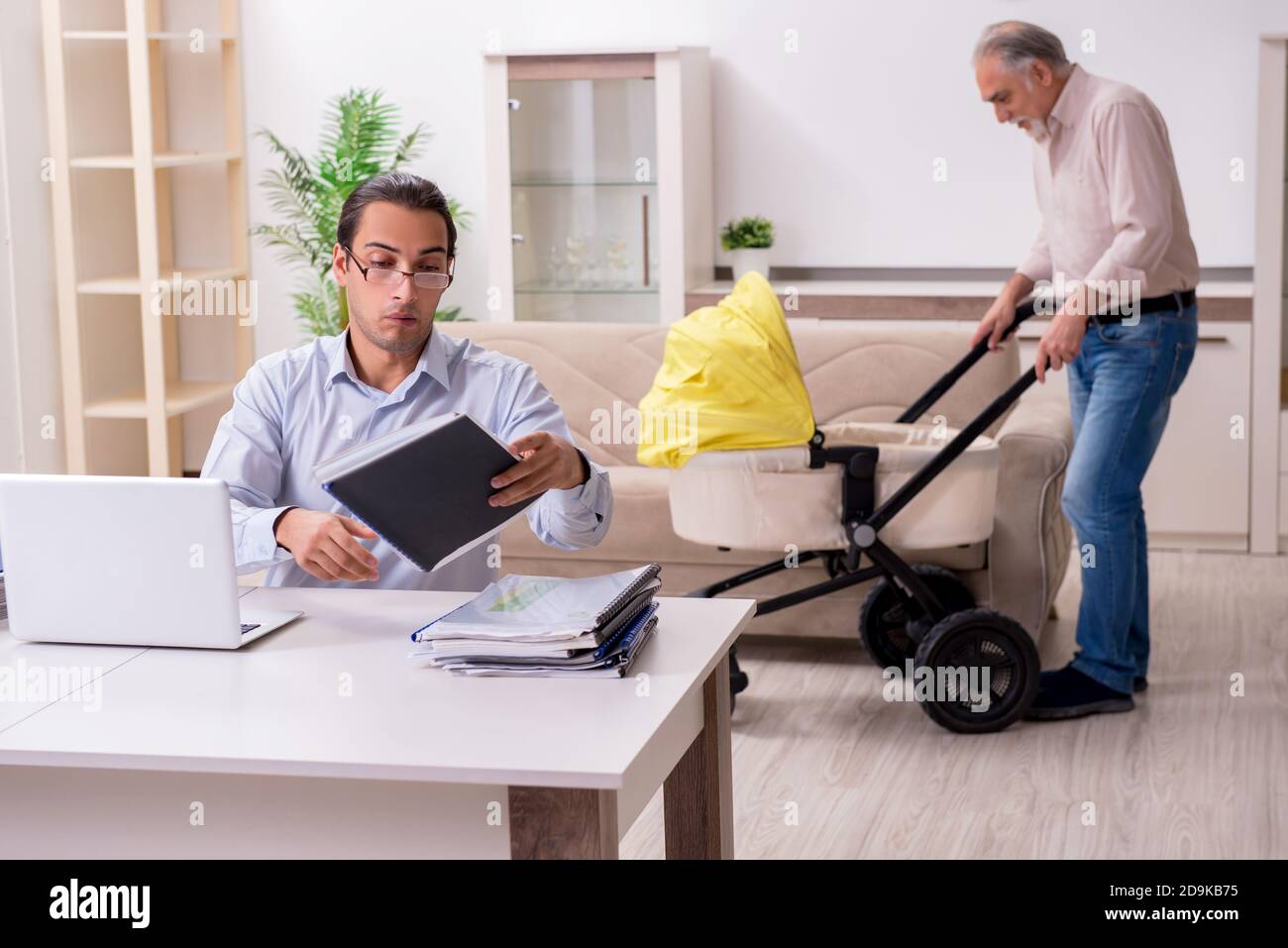 Old grandfather looking after newborn at home Stock Photo - Alamy