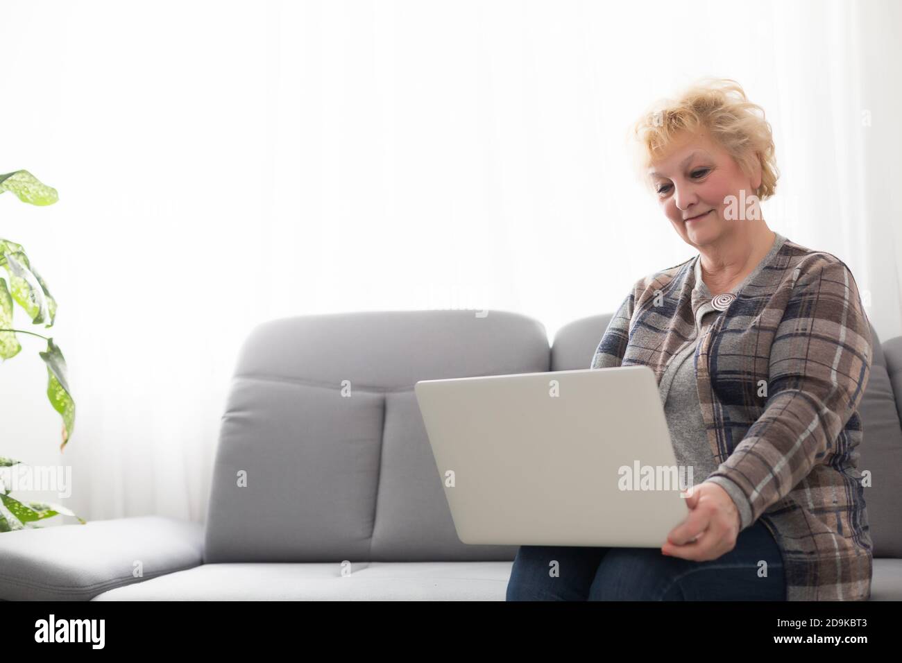 elderly woman senior at the computer communicates laptop, grandmother ...