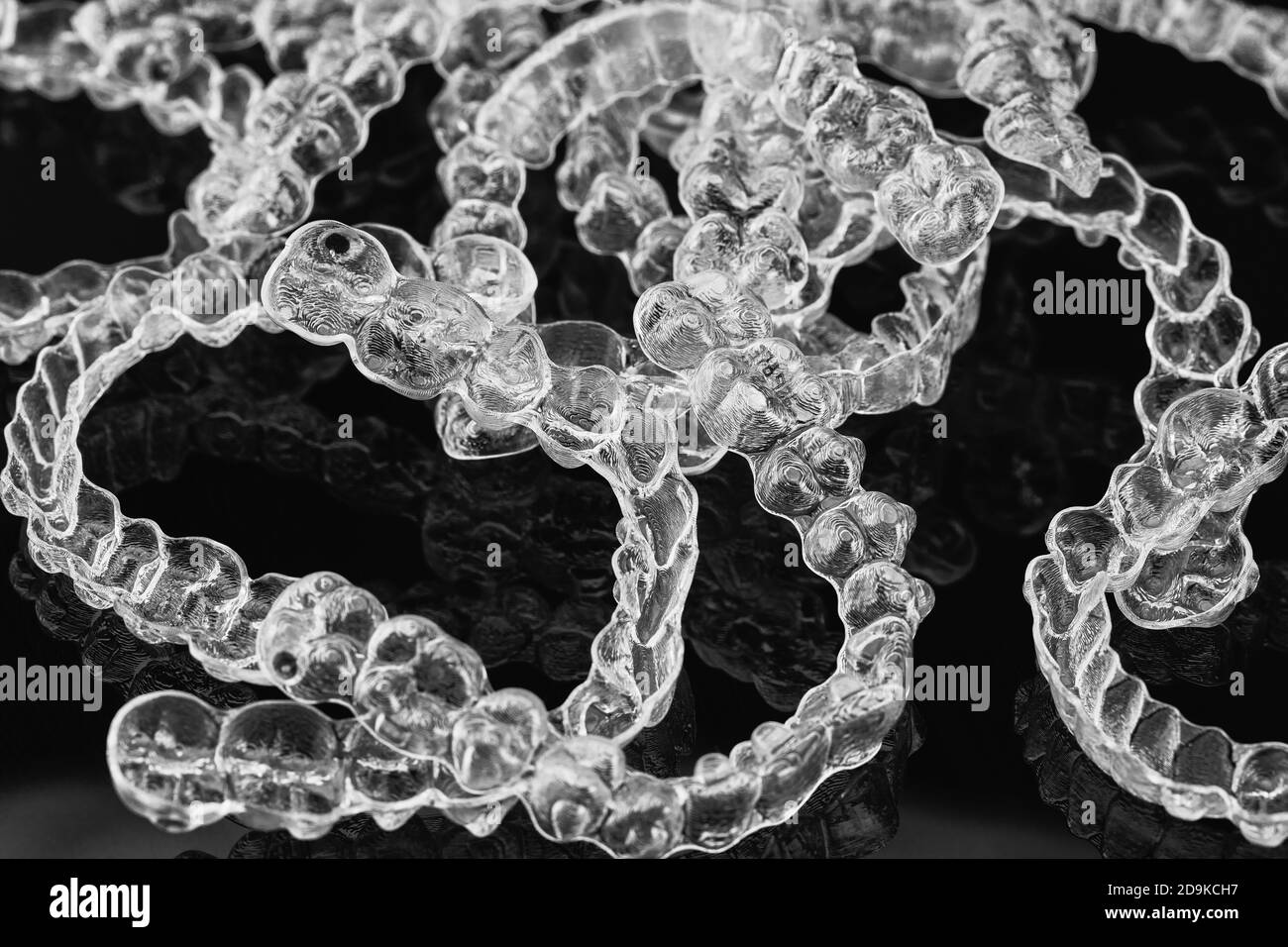 Invisible orthodontics cosmetic brackets on black background, tooth ...