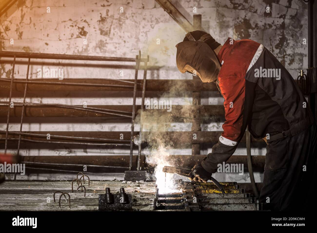 Industrial worker at a factory welding steel structure. A worker with a ...