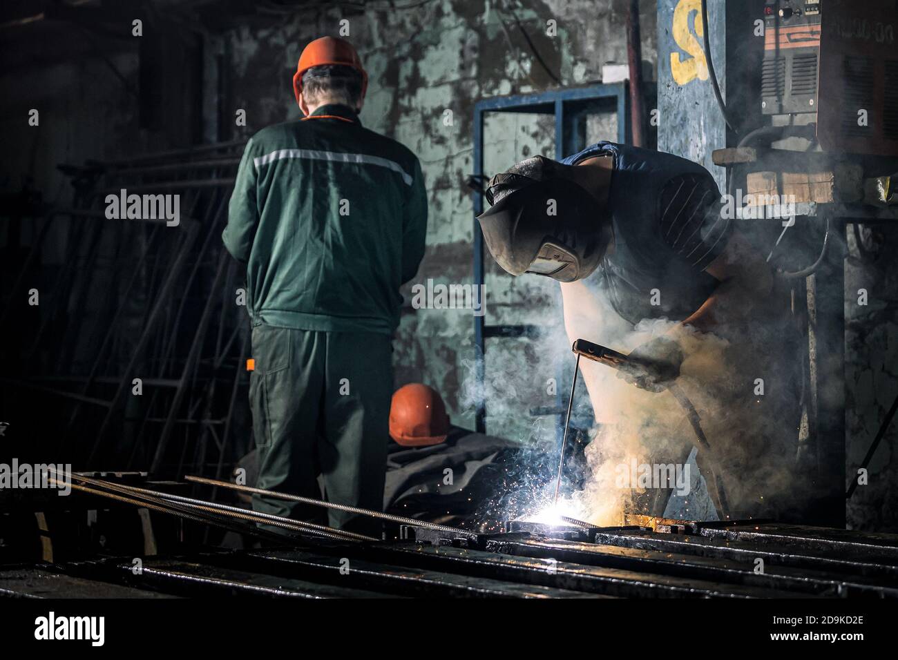 Industrial worker at a factory welding steel structure. A worker with a ...