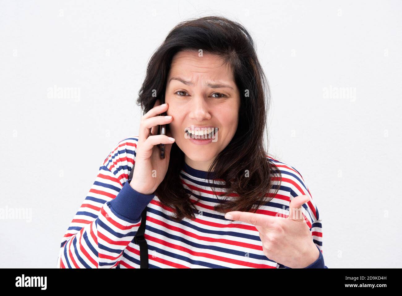 Close up portrait confused young woman talking with cellphone against ...