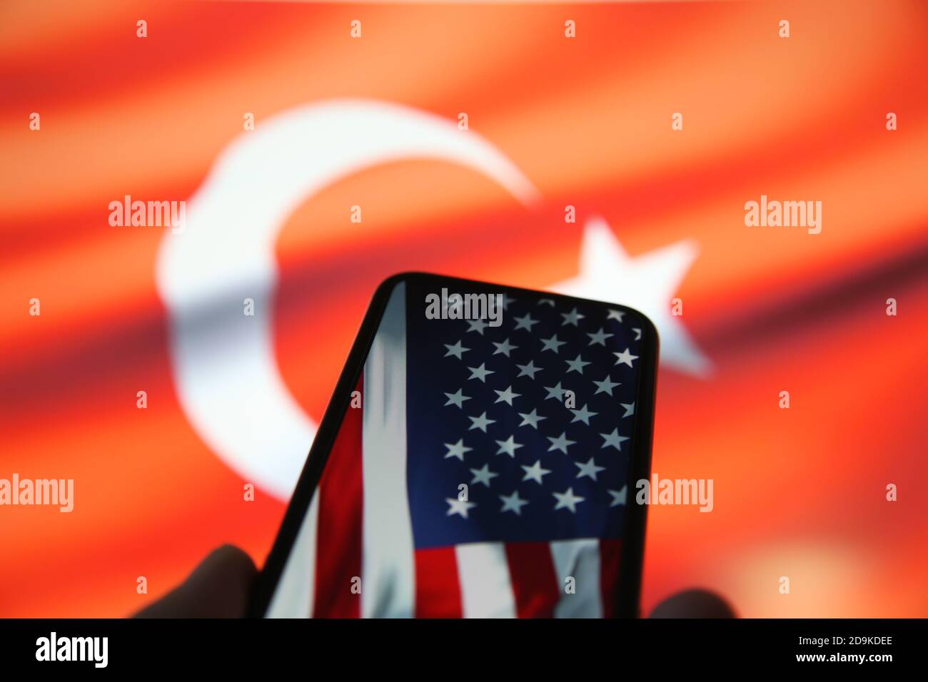 Closeup of mobile phone display with us american flag, turkish blurred ...