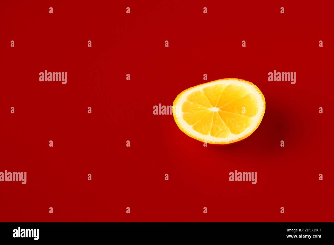 Bright yellow lemon on a red background Stock Photo - Alamy