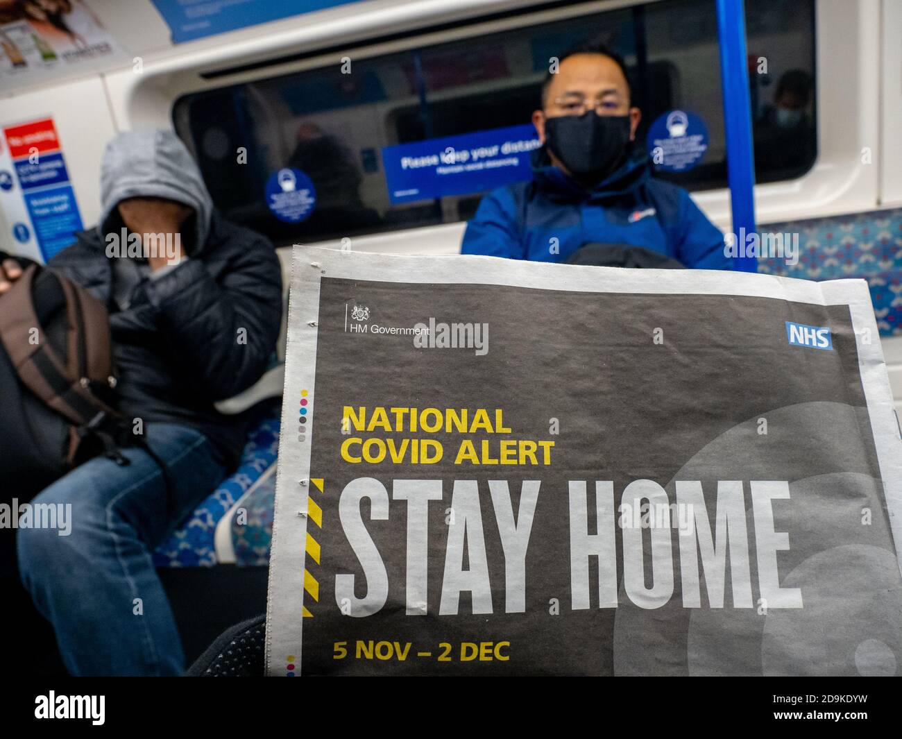 STAY HOME: government advice in a newspaper on a tube train during ...