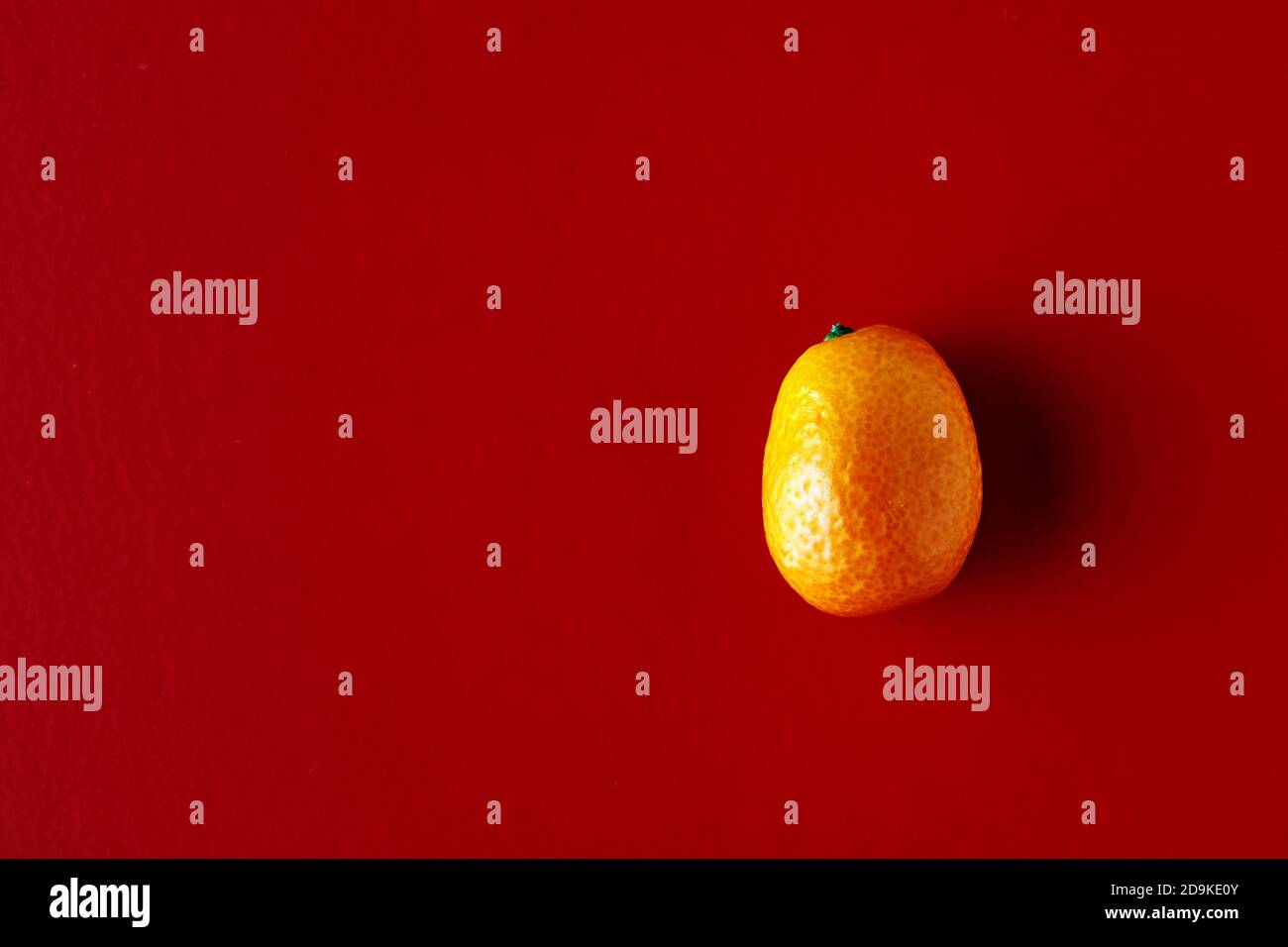 Bright Delicious Kum-Quat on a red background. Exotic fruit, vitamin ...