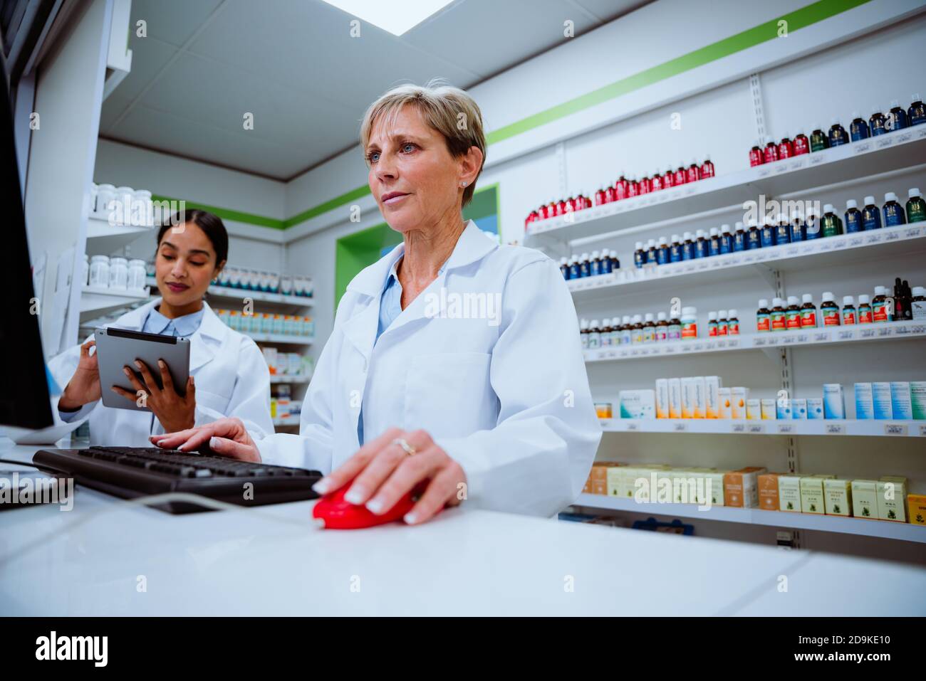 Caucasian pharmacist scrolling on desktop computer checking ...