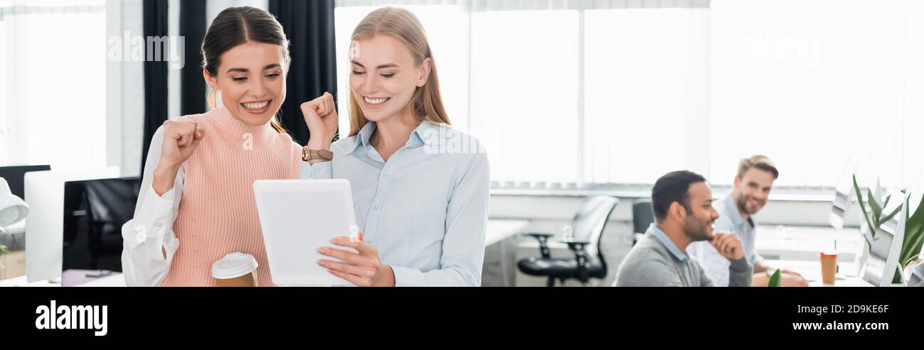 Cheerful businesswomen with coffee to go and digital tablet showing ...