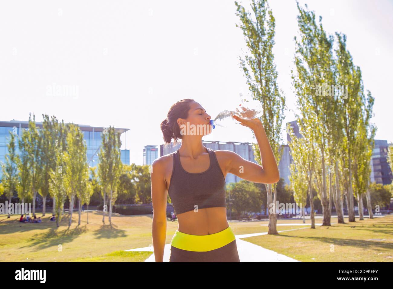 Female athlete drinking cold water after jogging in the morning Stock ...