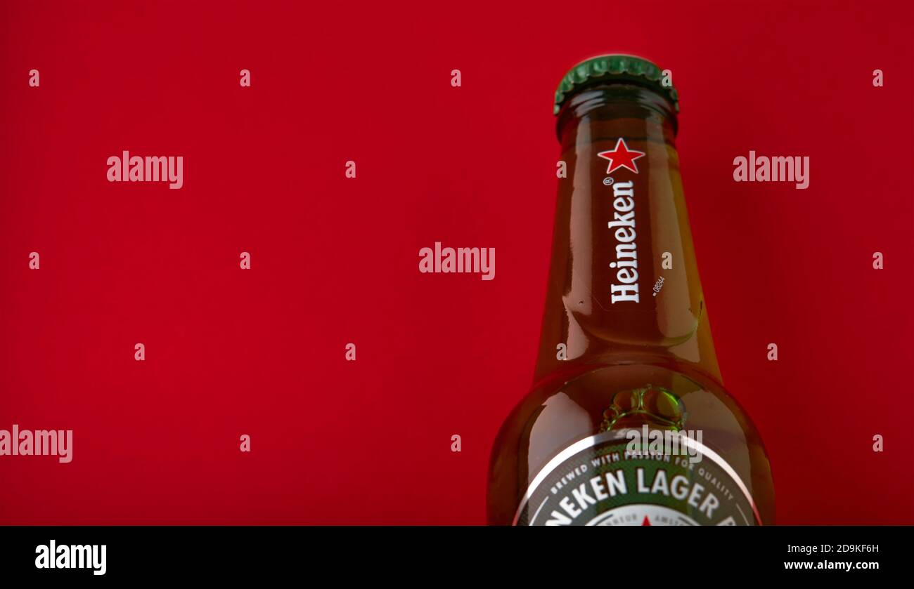 Bottle of Heineken Lager Beer on red background. Heineken is the ...