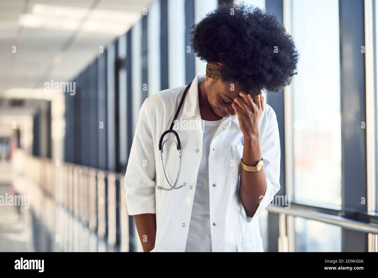 Sad and depressed young african american female doctor in white uniform ...