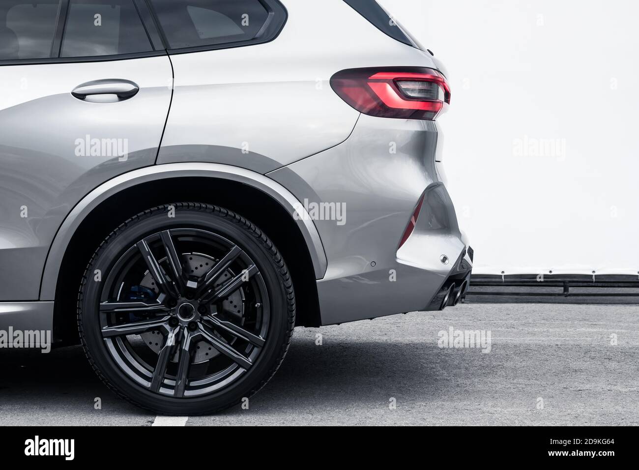The back of a silver expensive crossover car: wheel, taillight , bumper ...