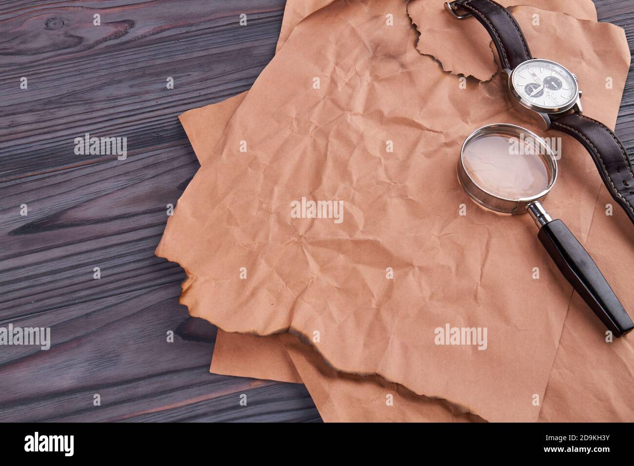Glass magnifier and watch clock on a beige paper Stock Photo - Alamy