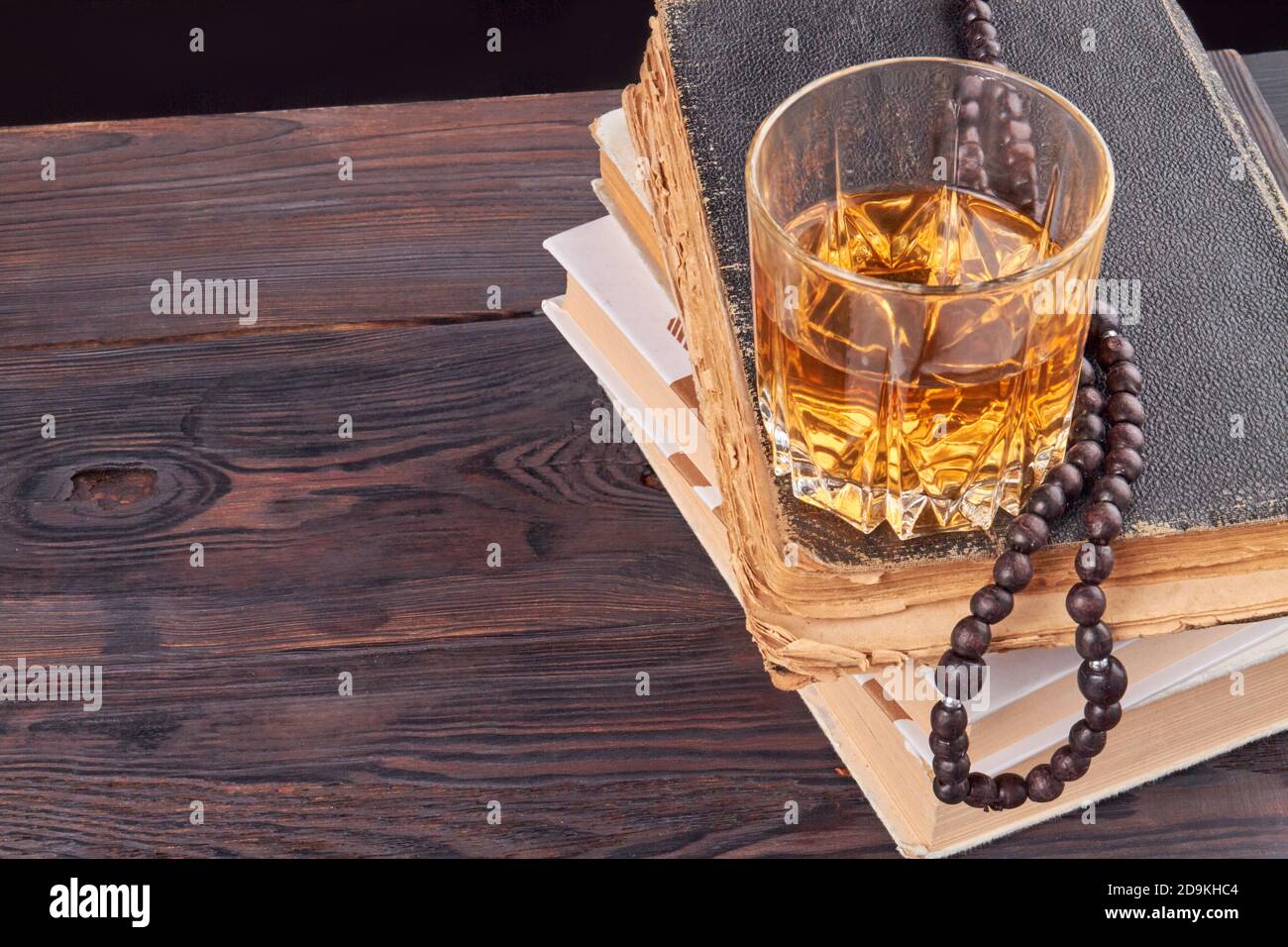 Glass cup with alcohol on a stack of books Stock Photo - Alamy