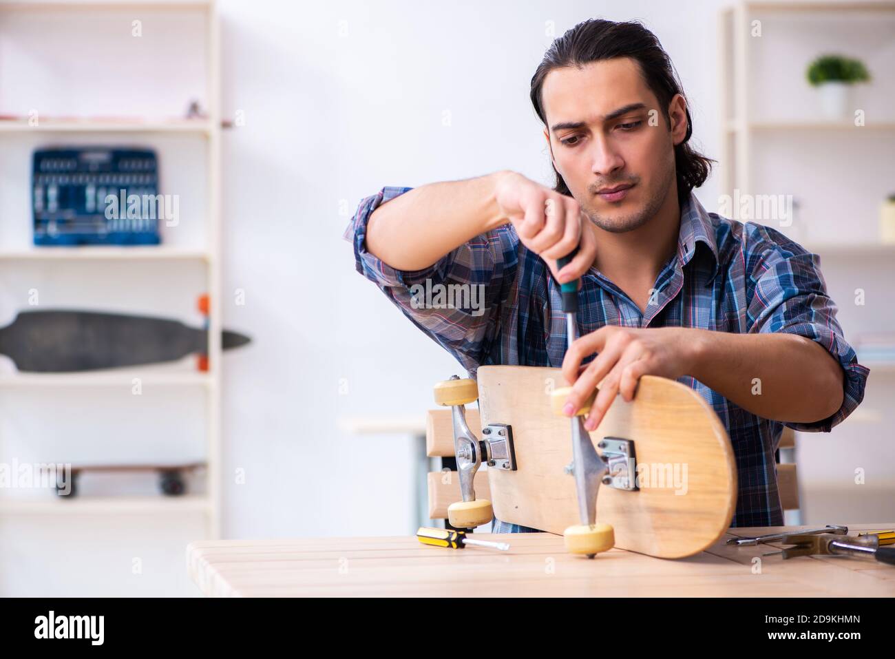 Man repairing skateboard at workshop Stock Photo - Alamy