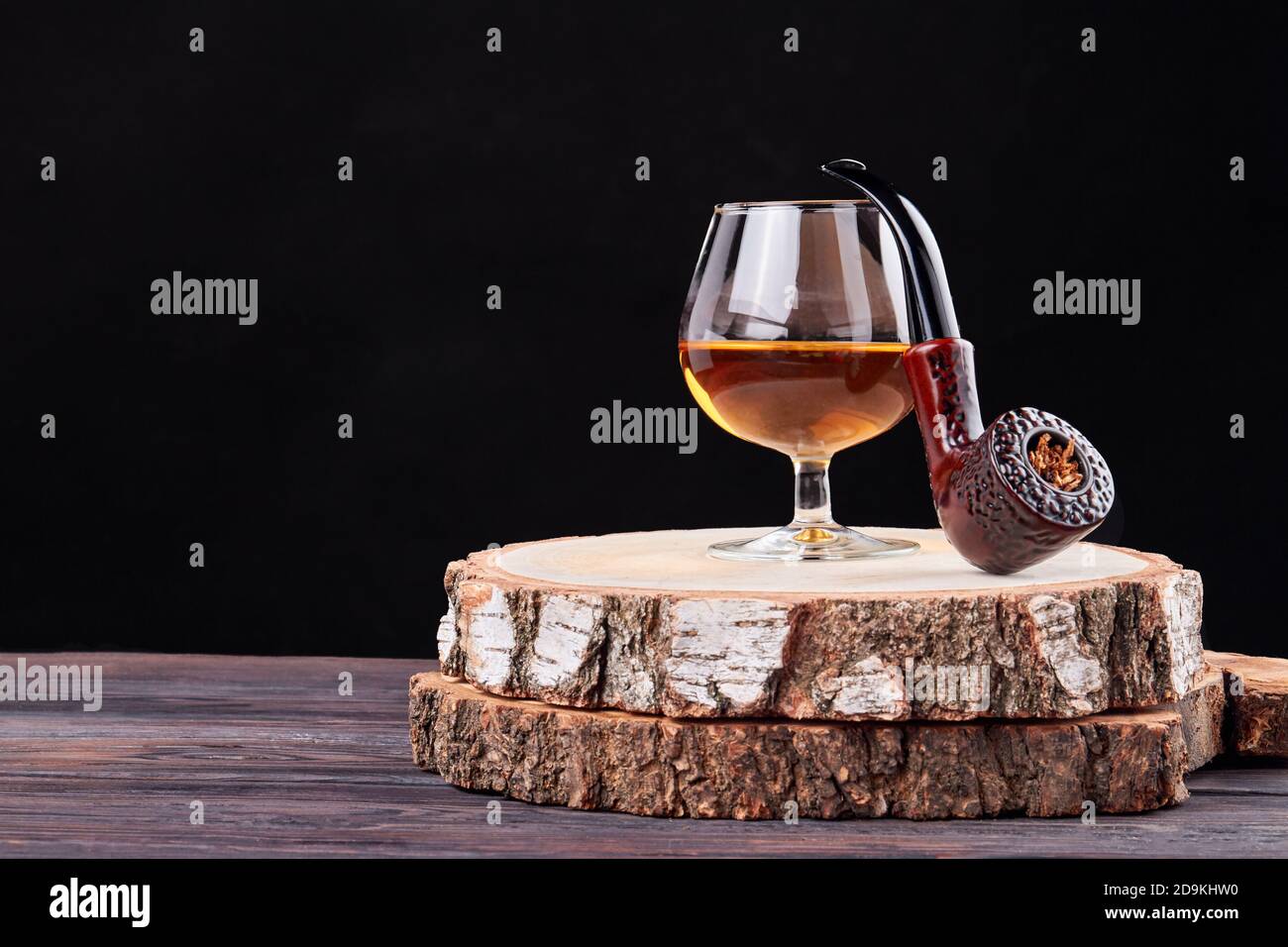 Still life glass of brandy and smoking pipe Stock Photo - Alamy