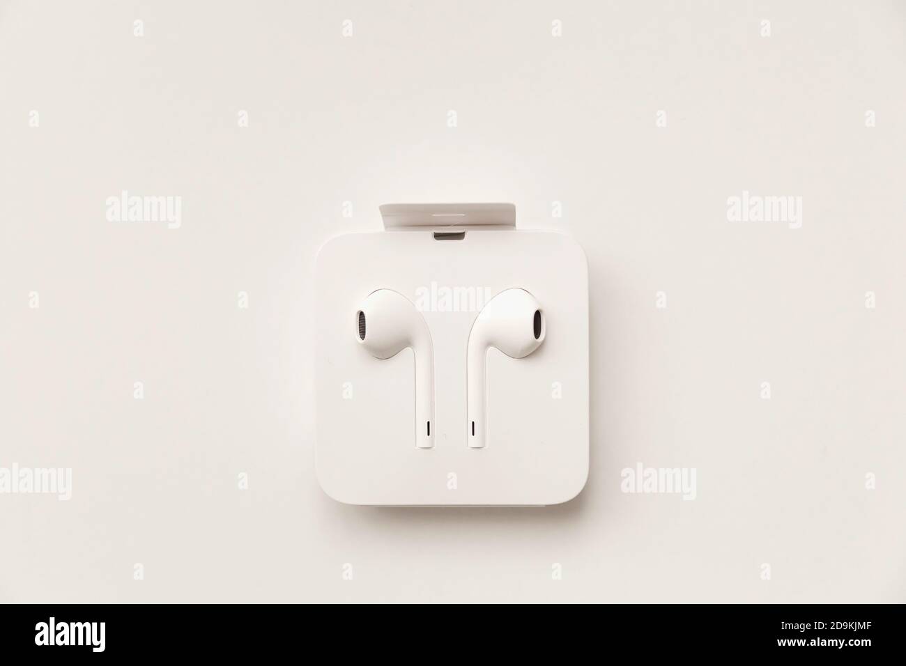 Modern white earphones packed into a box isolated on white background ...