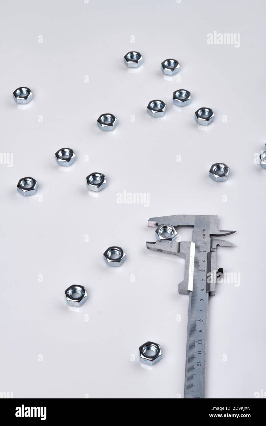 Vertical shot vernier caliper and nuts Stock Photo - Alamy