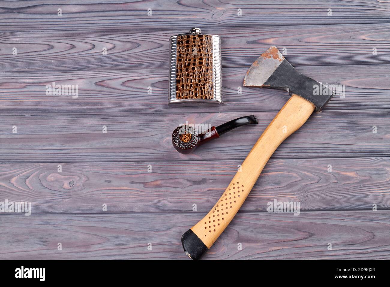 Axe with flask of whiskey and smoking pipe Stock Photo - Alamy