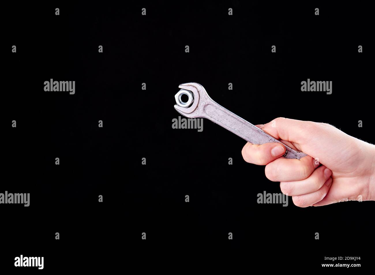 Hands holding a wrench with nut Stock Photo - Alamy