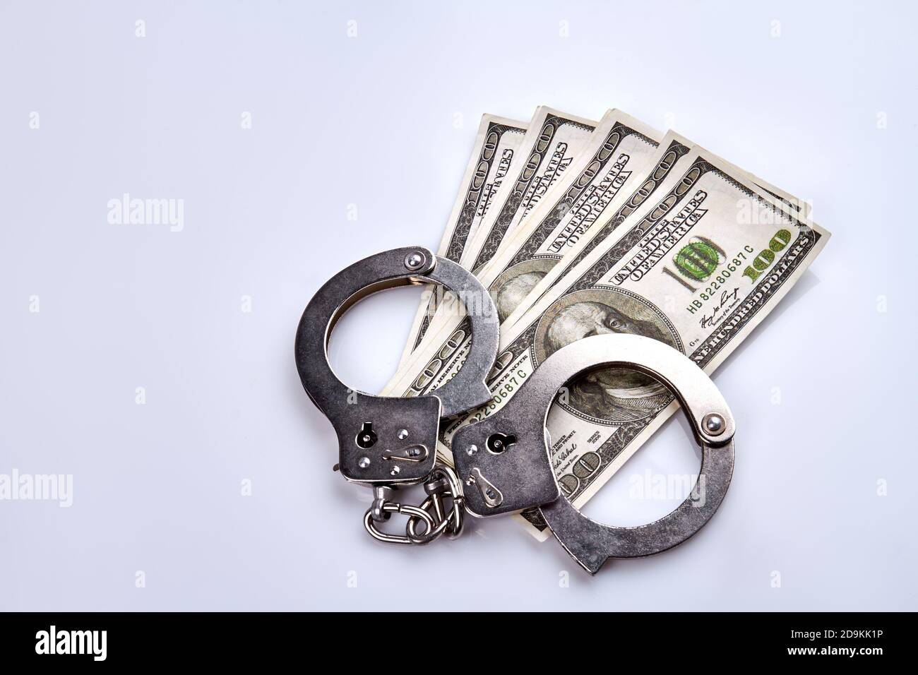 Handcuffs and money isolated on white Stock Photo - Alamy