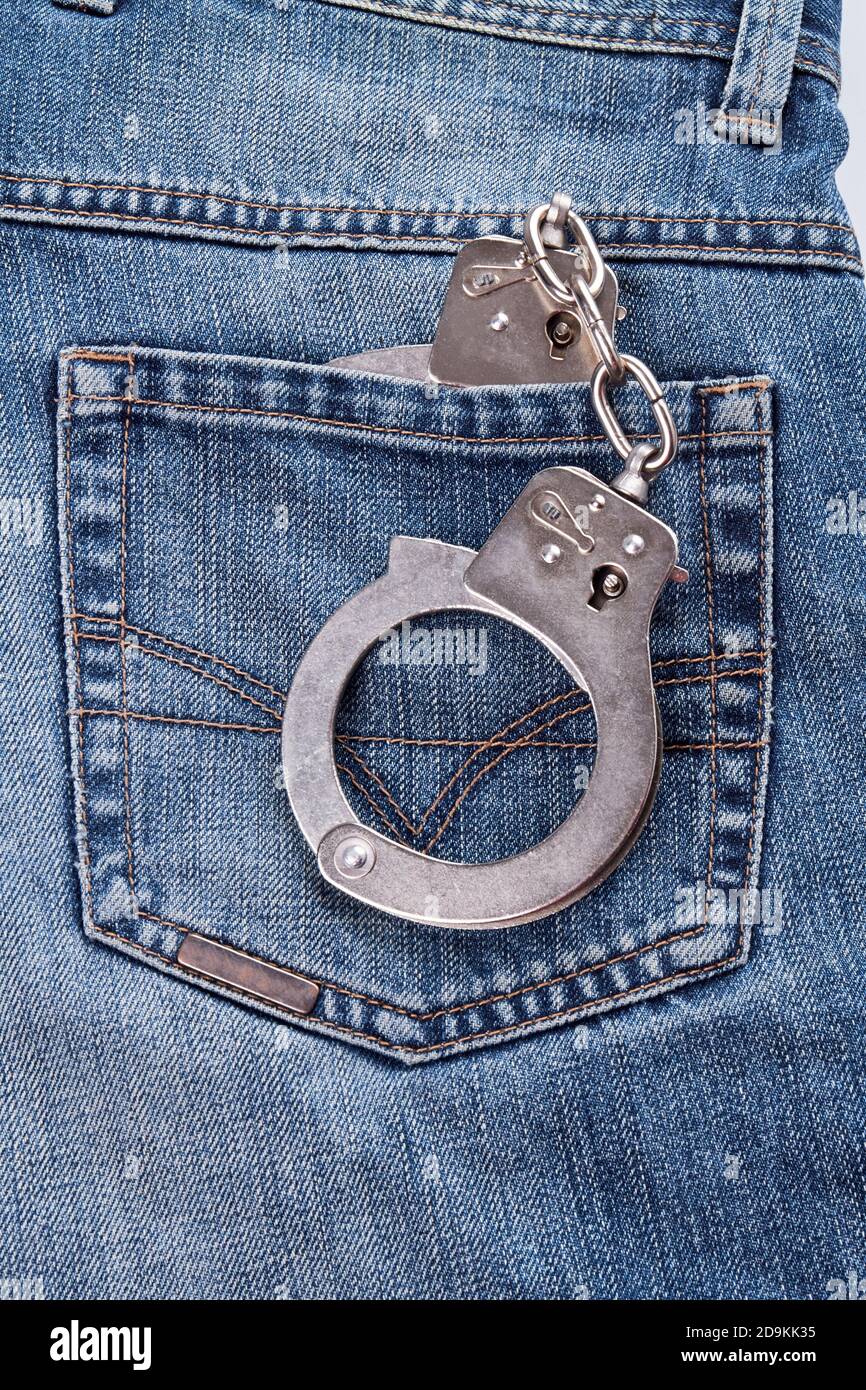 Handcuffs on a jeans back pocket Stock Photo - Alamy