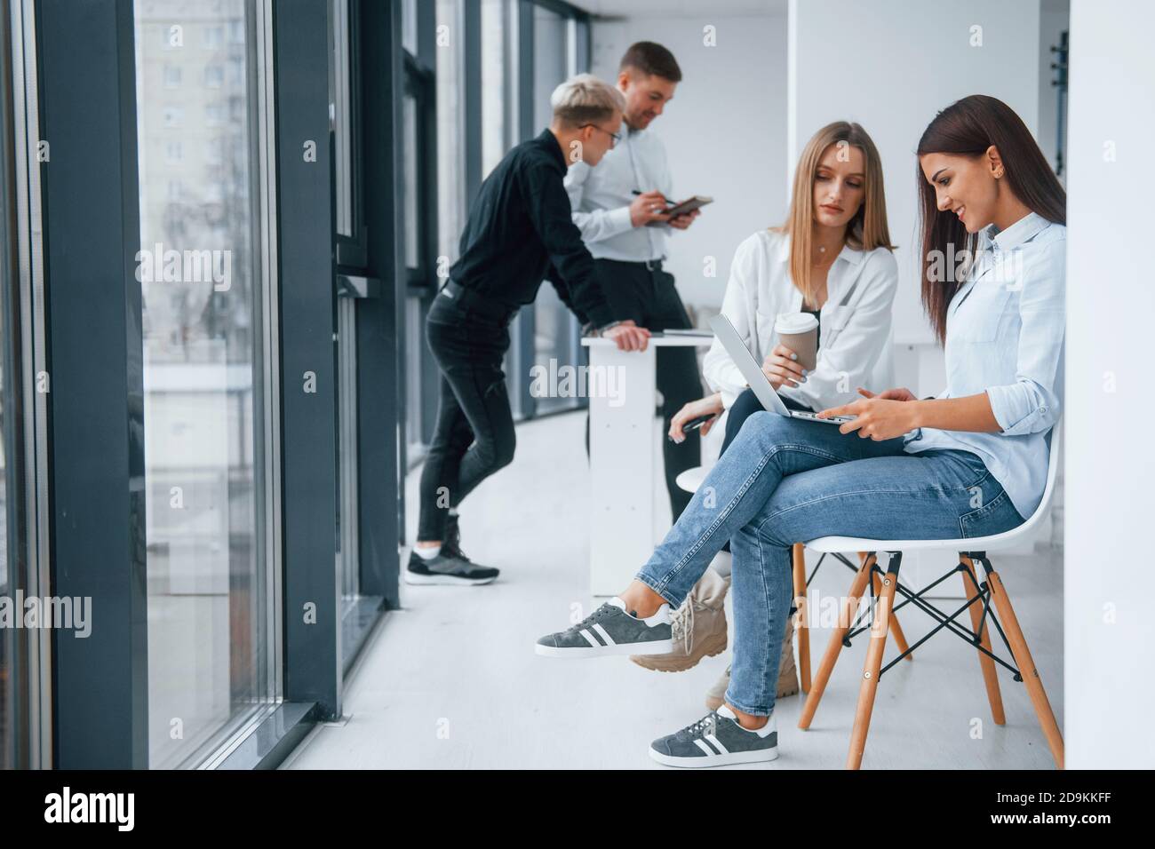 Group of young successful team sitting and working together indoors in ...