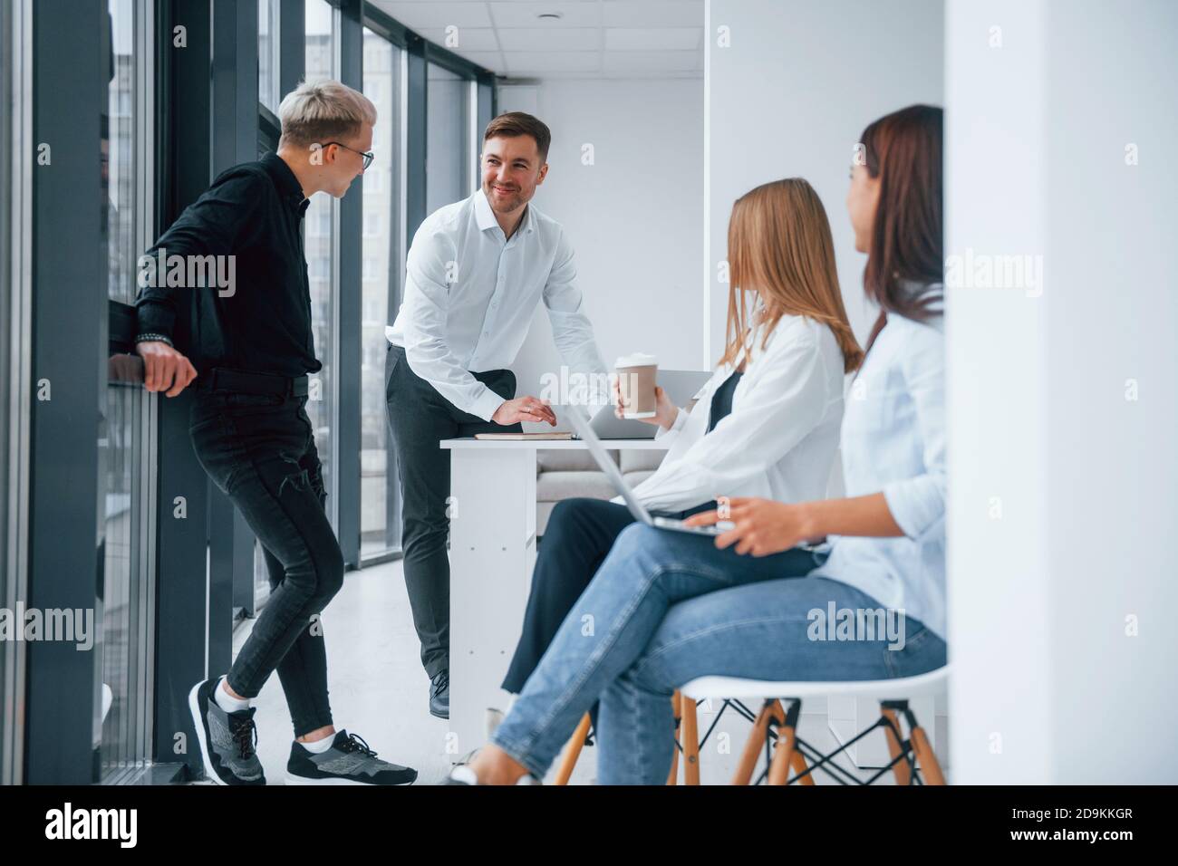 Group of young successful team sitting and working together indoors in ...