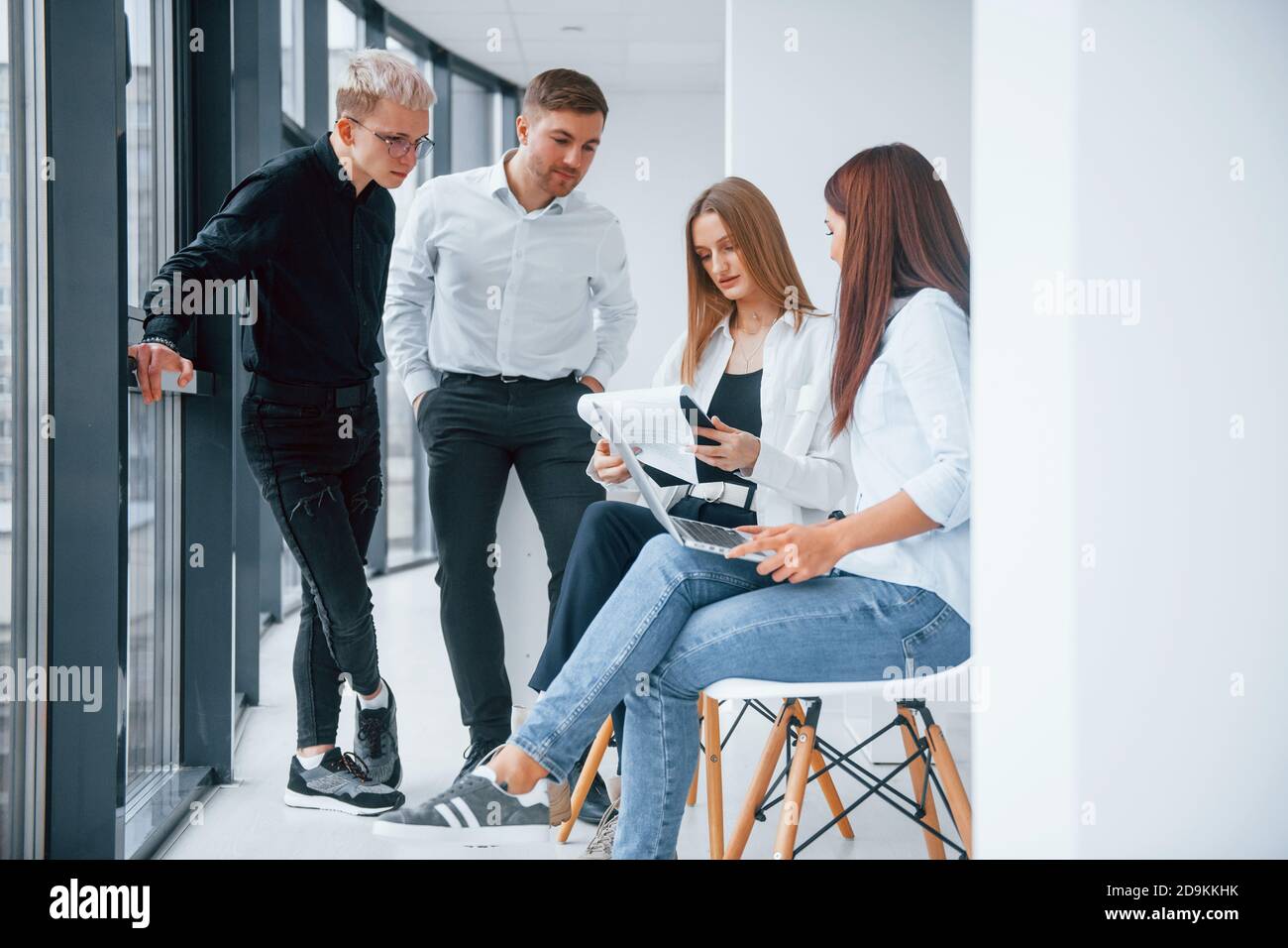 Group of young successful team sitting and working together indoors in ...