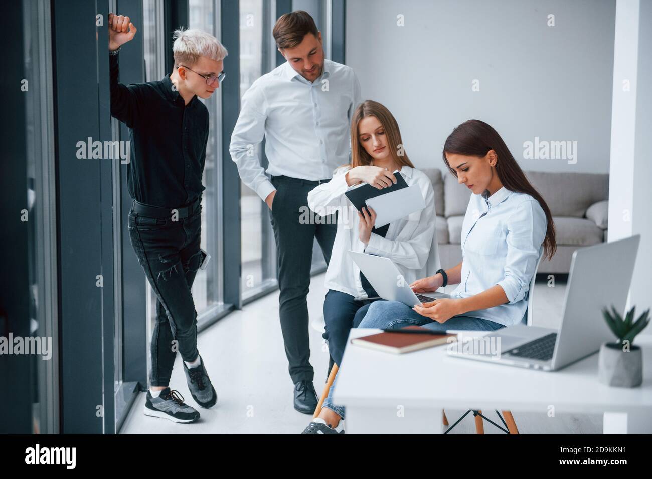 Group of young successful team sitting and working together indoors in ...