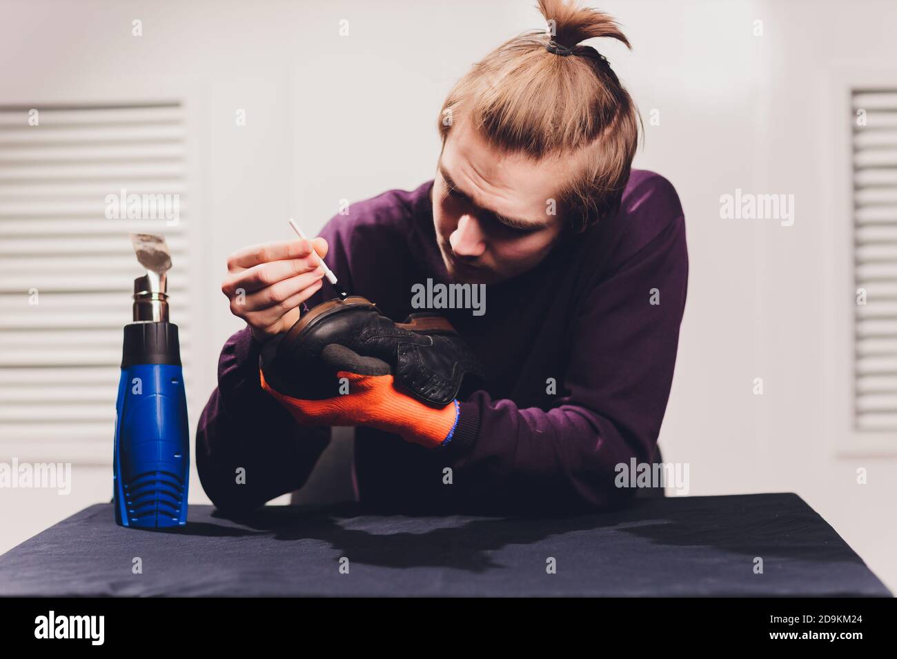 A shoemaker cuts the sole of a Shoe with a shoemaker's automatic cutter ...