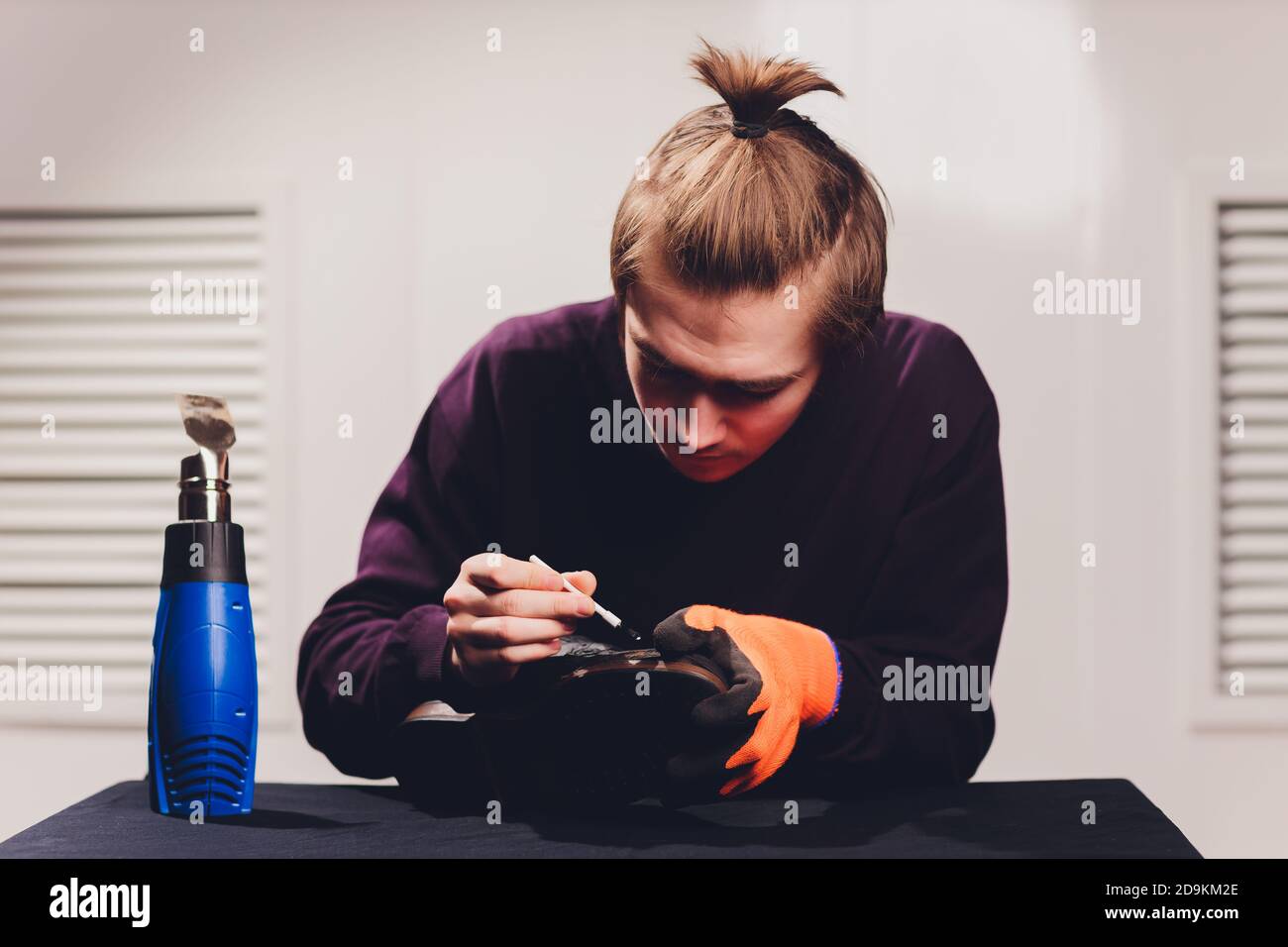A shoemaker cuts the sole of a Shoe with a shoemaker's automatic cutter ...