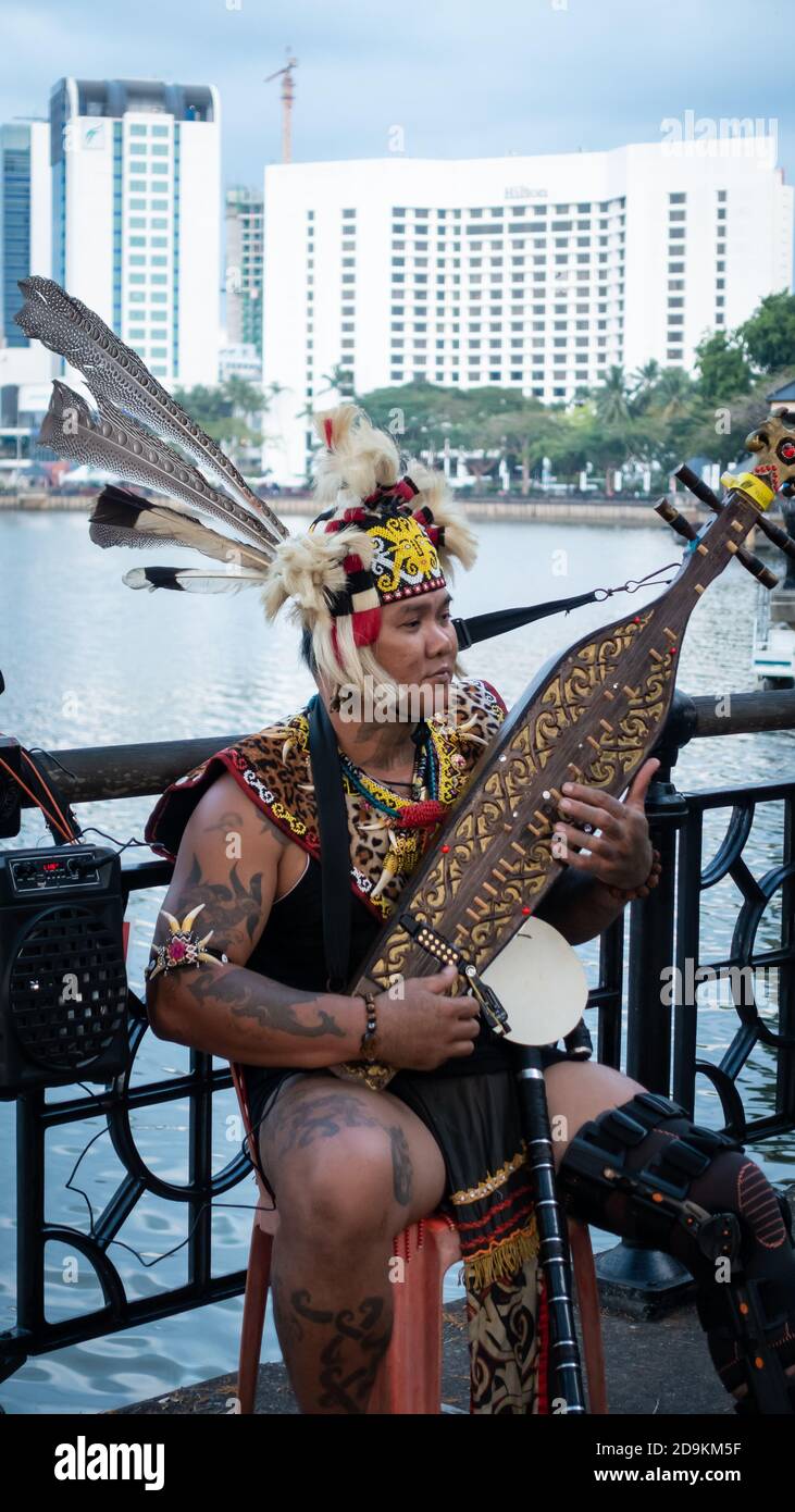 Sarawakian Man playing Sape, traditional Sarawak Musical instrument ...