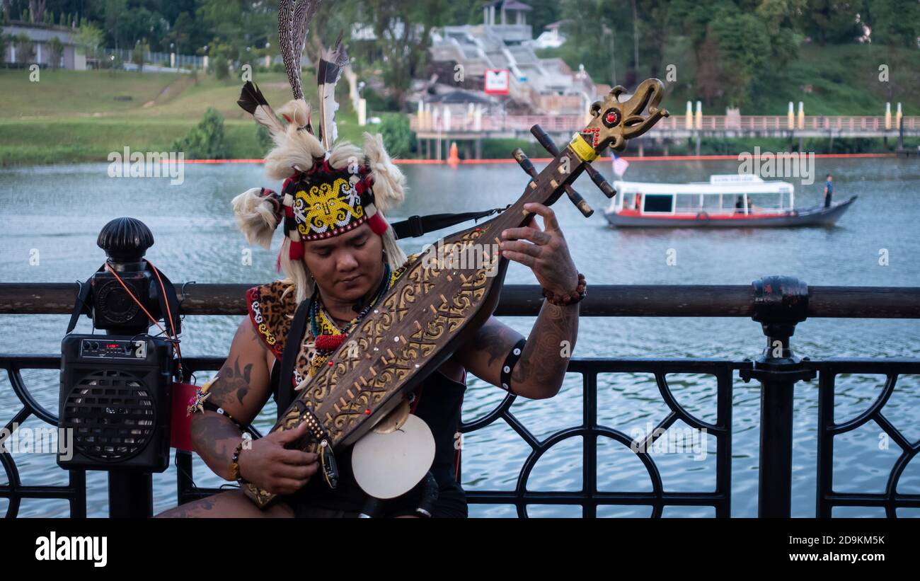 Sarawakian Man playing Sape, traditional Sarawak Musical instrument ...