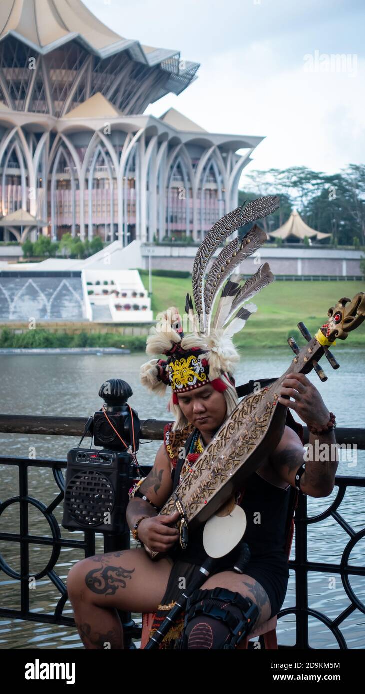 Sarawakian Man playing Sape, traditional Sarawak Musical instrument ...