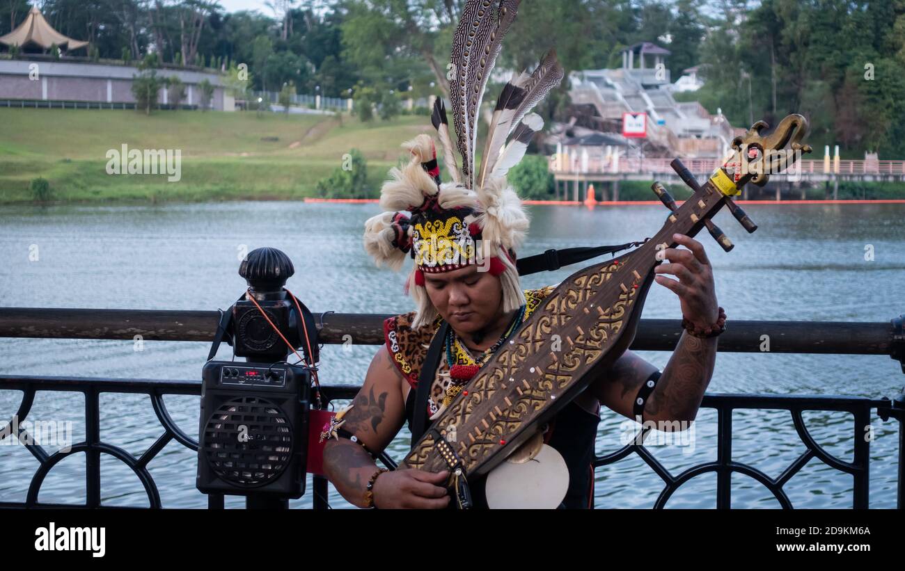 Sarawakian Man playing Sape, traditional Sarawak Musical instrument ...
