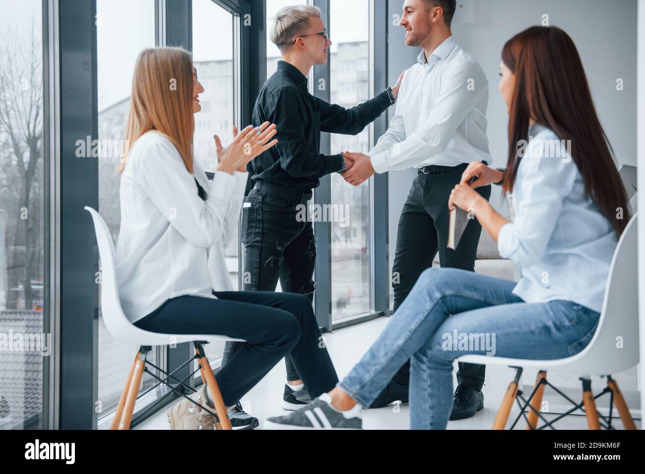 Successful agreement. Doing handshake. Group of young successful team ...