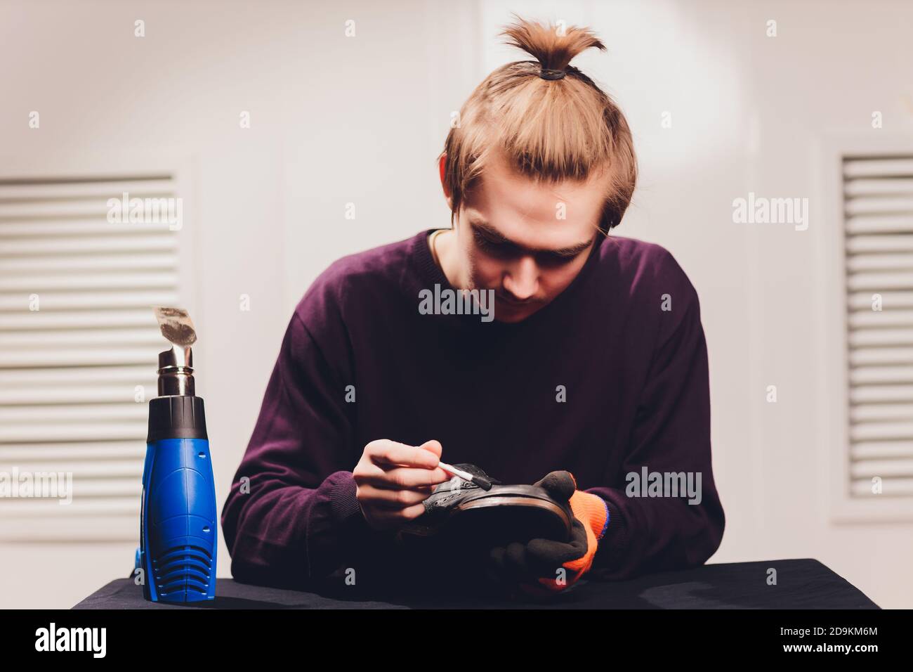 A shoemaker cuts the sole of a Shoe with a shoemaker's automatic cutter ...