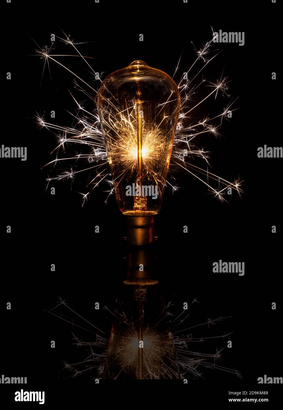 Antique Light Bulb on black background, emitting showers of sparks on ...