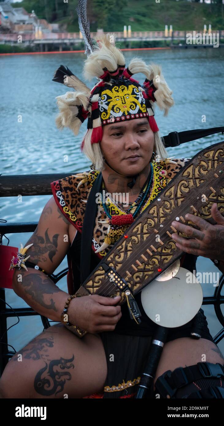 Sarawakian Man playing Sape, traditional Sarawak Musical instrument ...