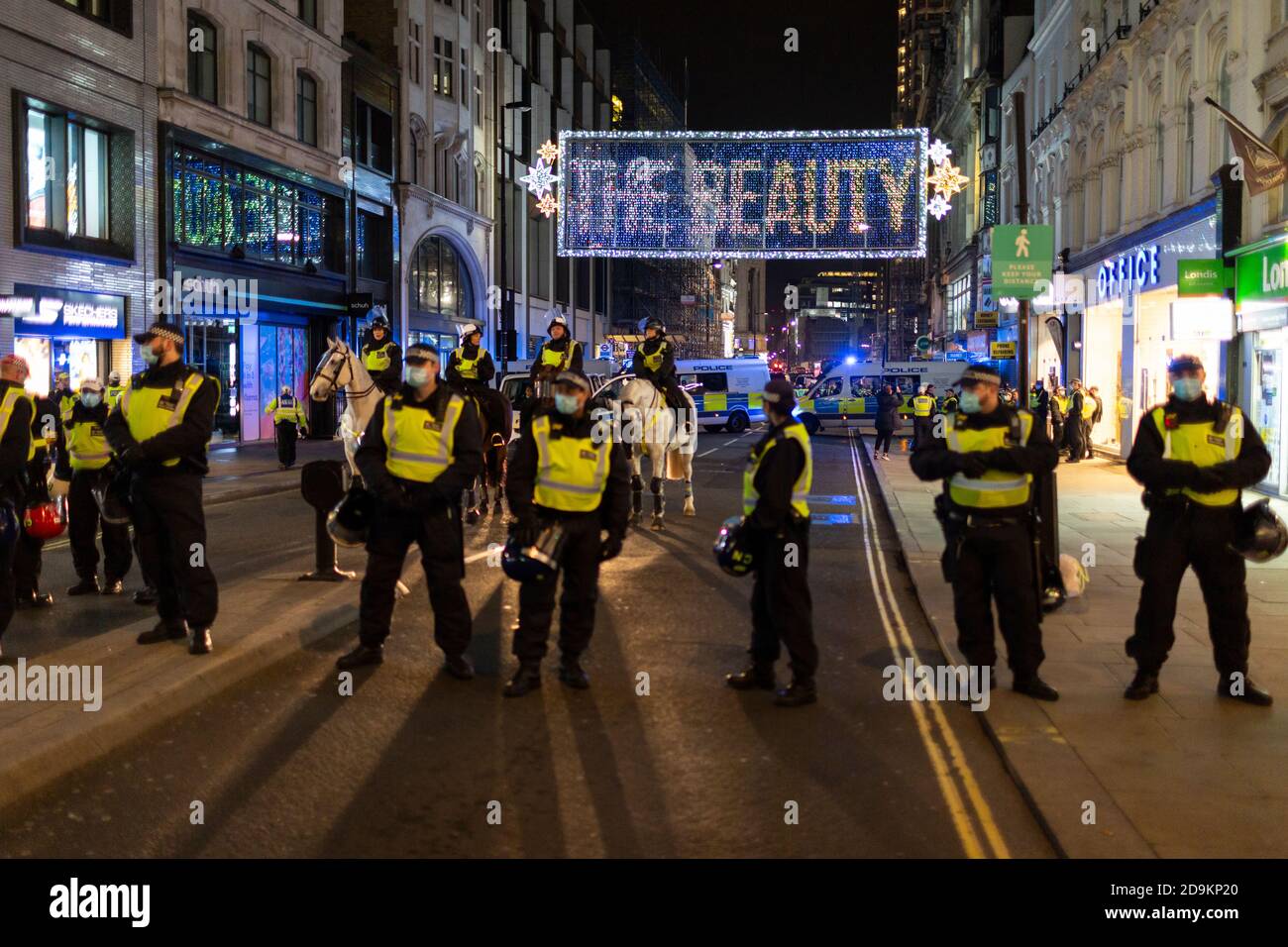 Police officers with Christmas lights overhead during the Million Mask ...