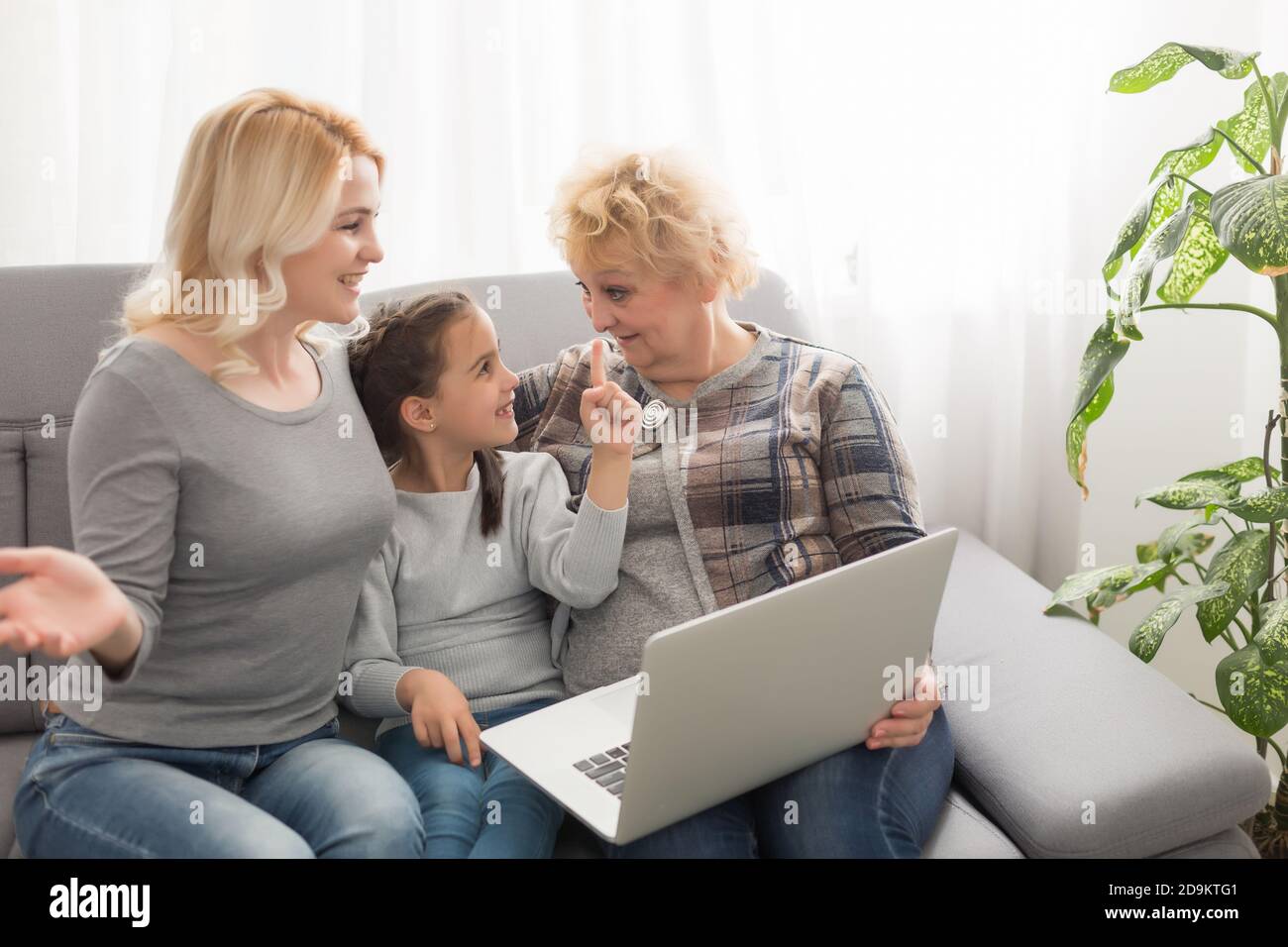 Grandmother and daughter teaching child use laptop application, playing ...