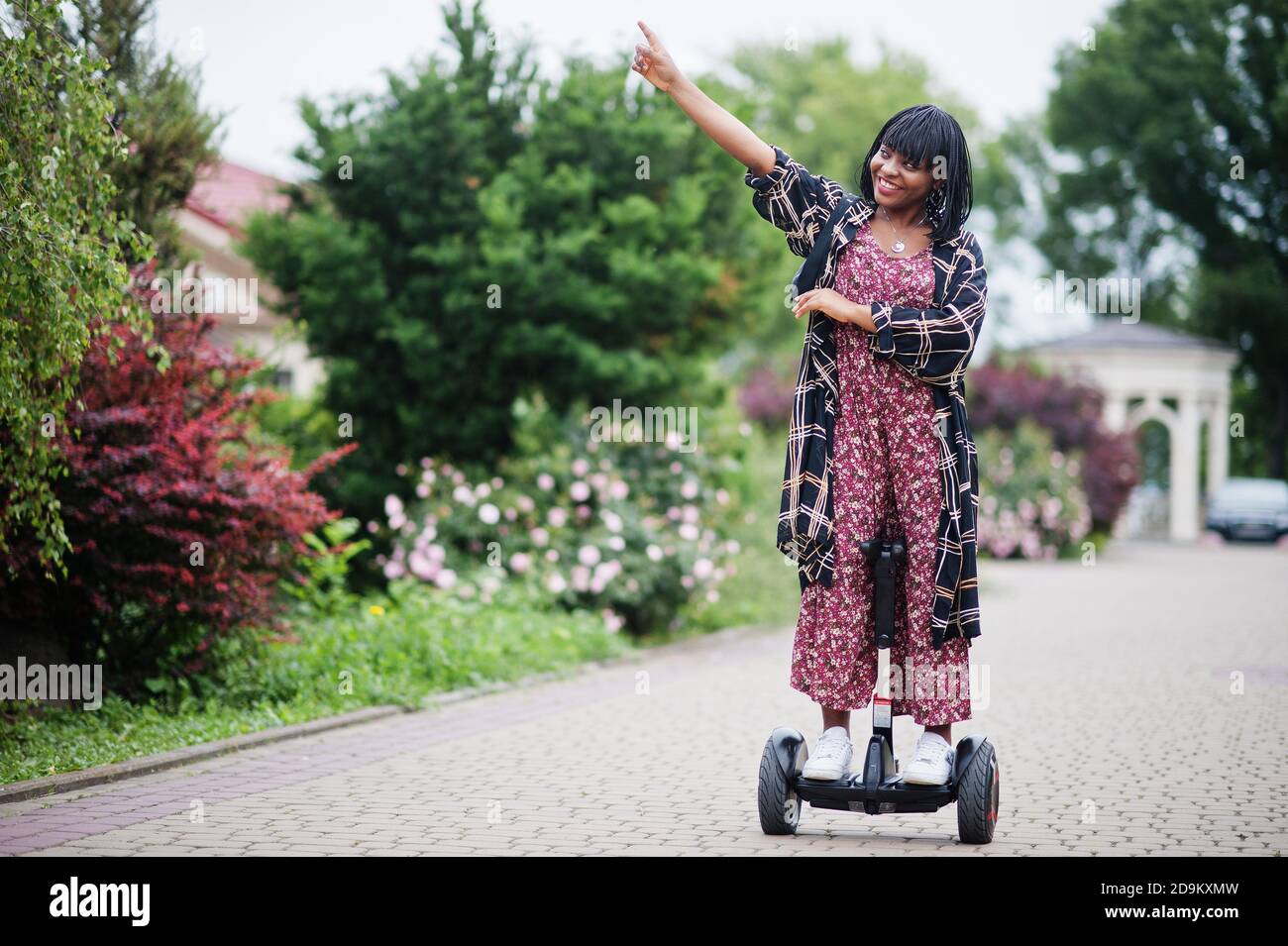 Beautiful african american woman using segway or hoverboard. Black girl ...