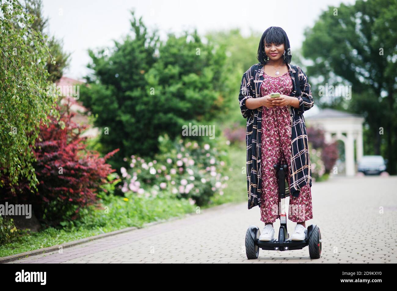 Beautiful african american woman using segway or hoverboard. Black girl ...