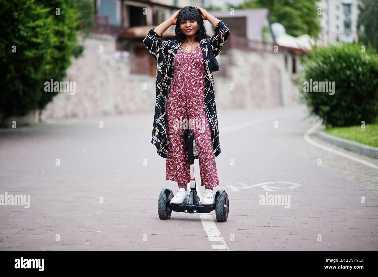 Beautiful african american woman using segway or hoverboard. Black girl ...