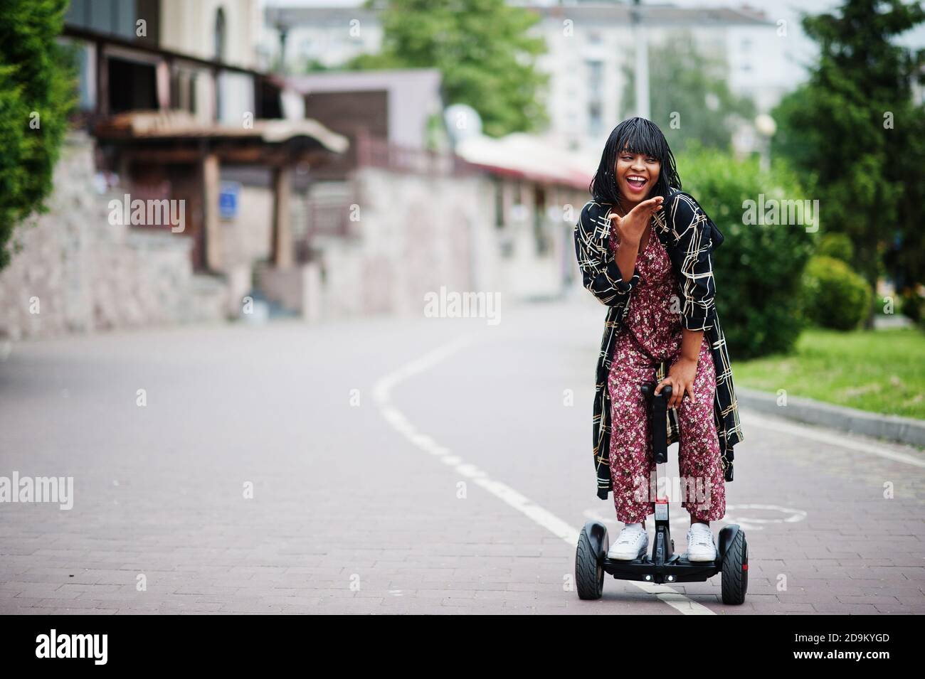 Beautiful african american woman using segway or hoverboard. Black girl ...