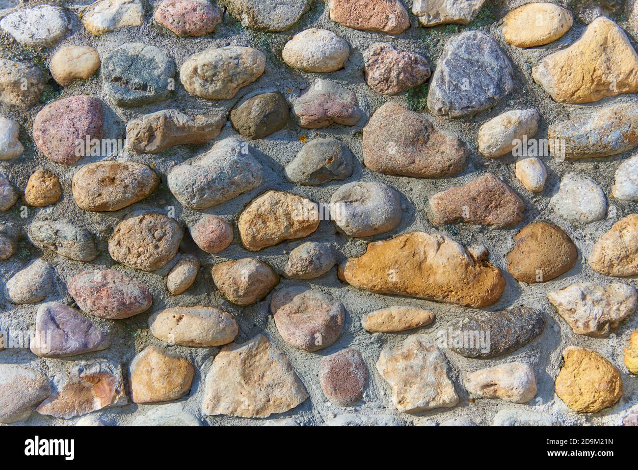 Full frame stonework made of cobblestones of different colors and sizes ...