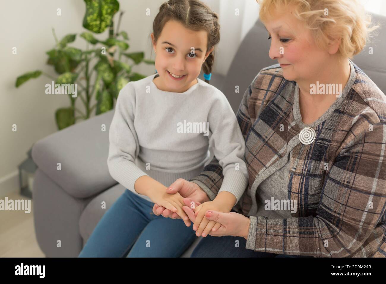 Portrait of happy old grandmother and kid girl looking at camera ...