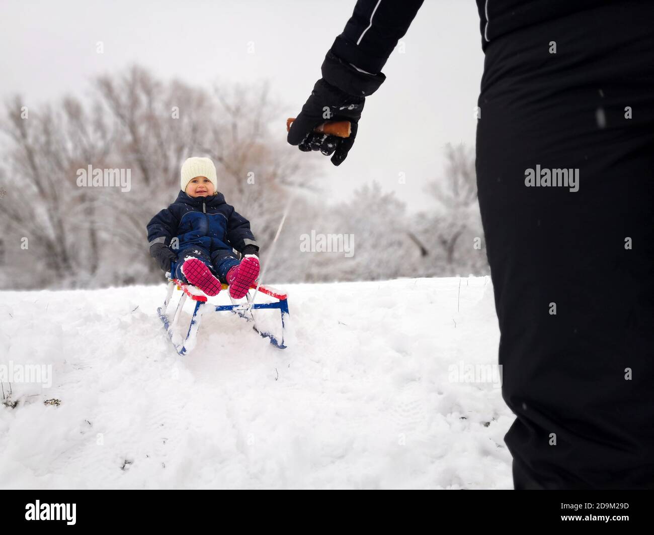 Childhood, sledding, leisure concept. Parent carrying happy little kid ...